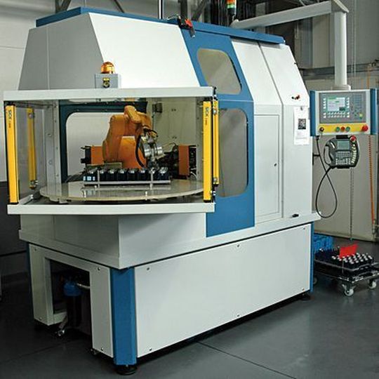 Roboter führt Rotationskolben lagerichtig einer Schleifmaschine zu